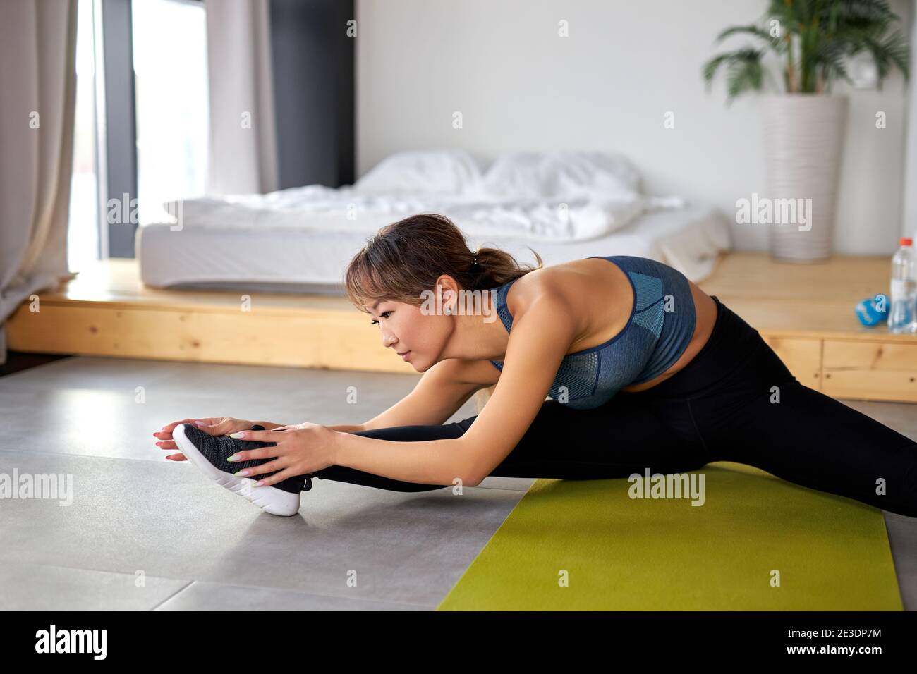 asian woman stretching legs, doing exercises on mat, workout. healthy ...