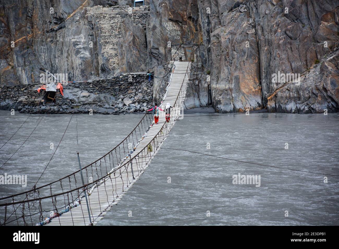 Aerial shot of a long hanging bridge over the water leading to the ...