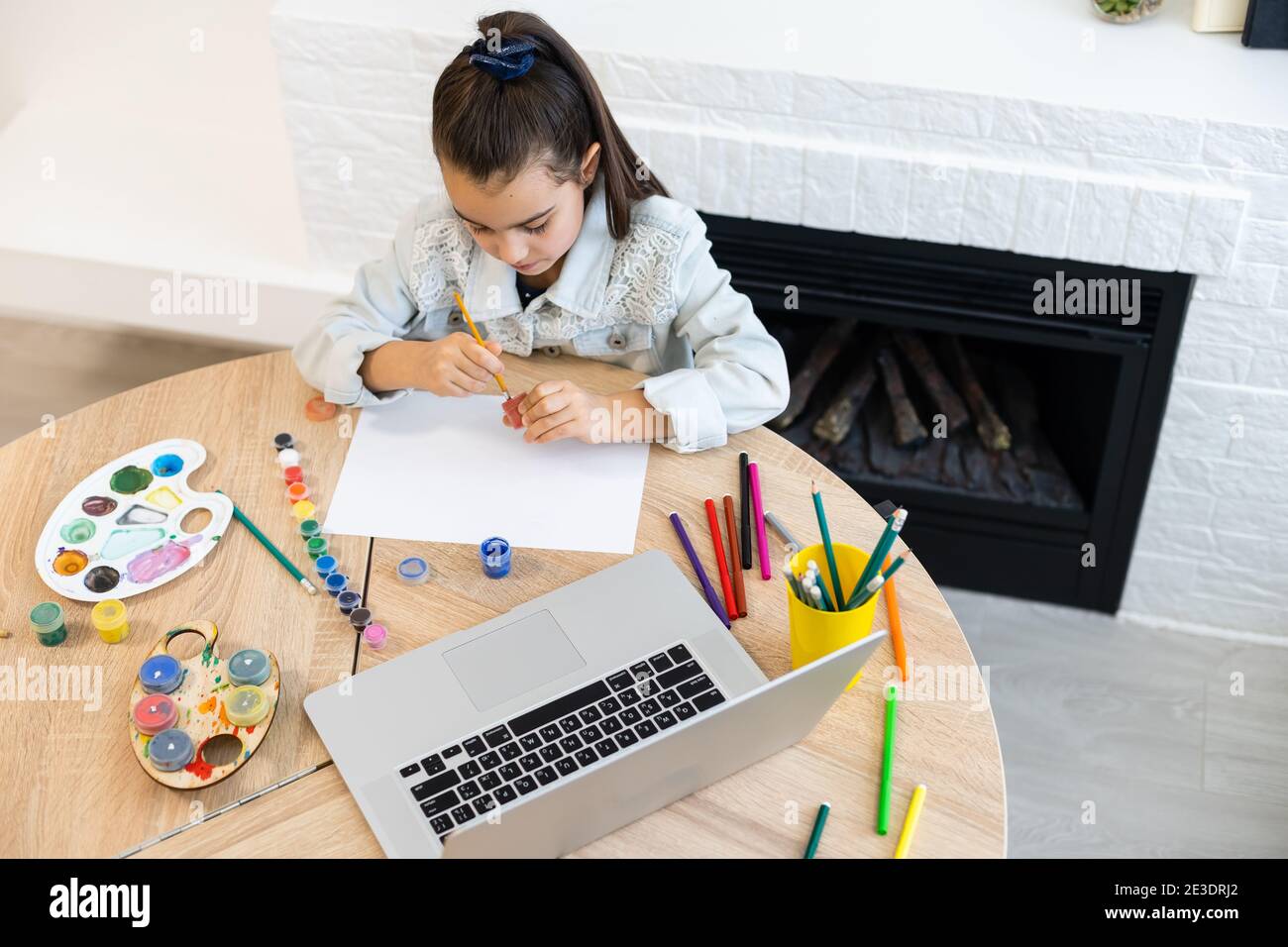 Young girl spending a time drawing using online lessons on laptop ...