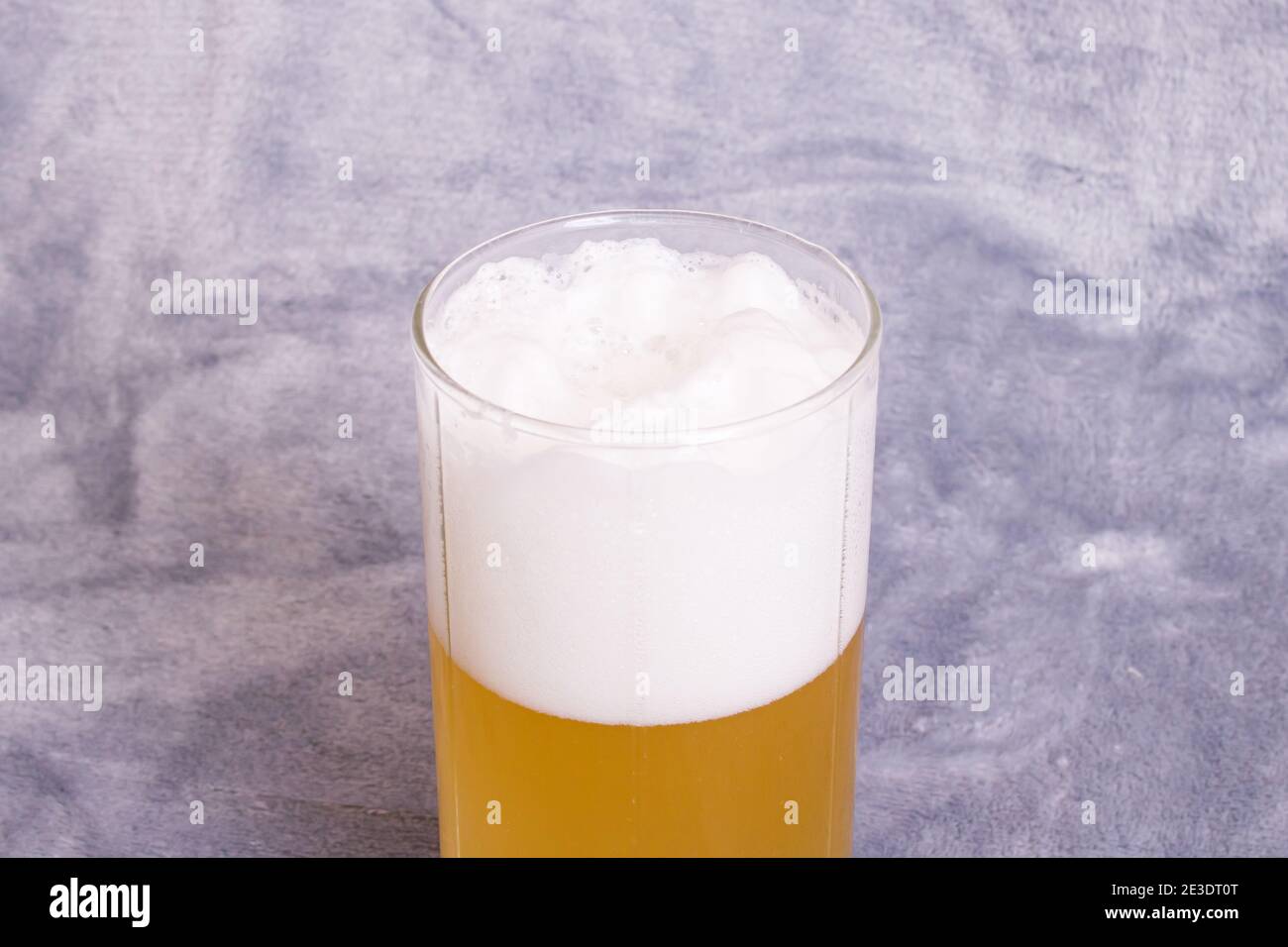 Beer with foam in a transparent glass close up Stock Photo - Alamy