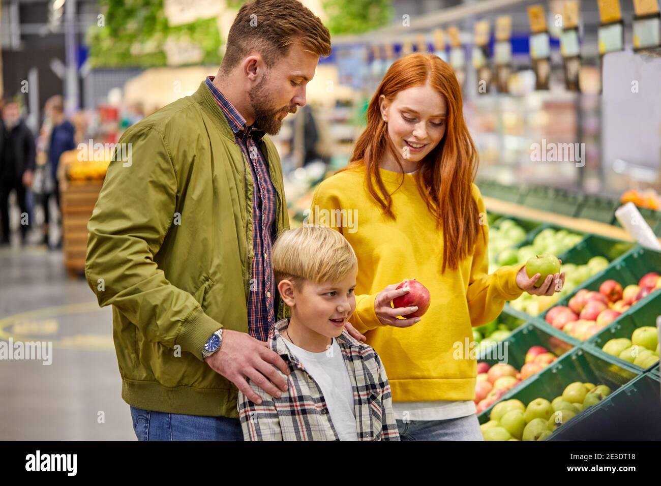 family with child boy in food store, caucasian parents and kid buying ...