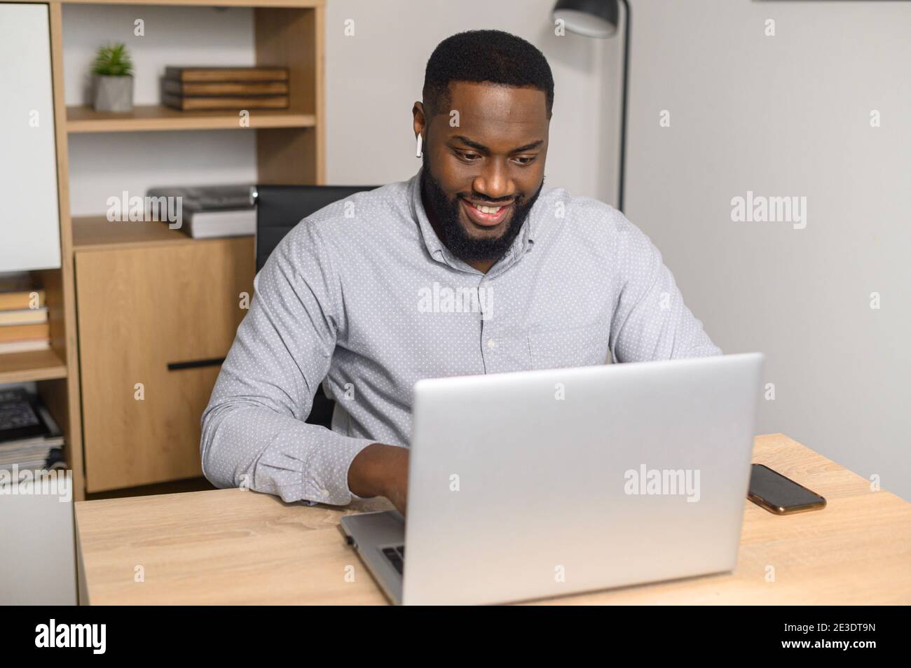 Excited AfricanAmerican male worker writing email Stock Photo - Alamy