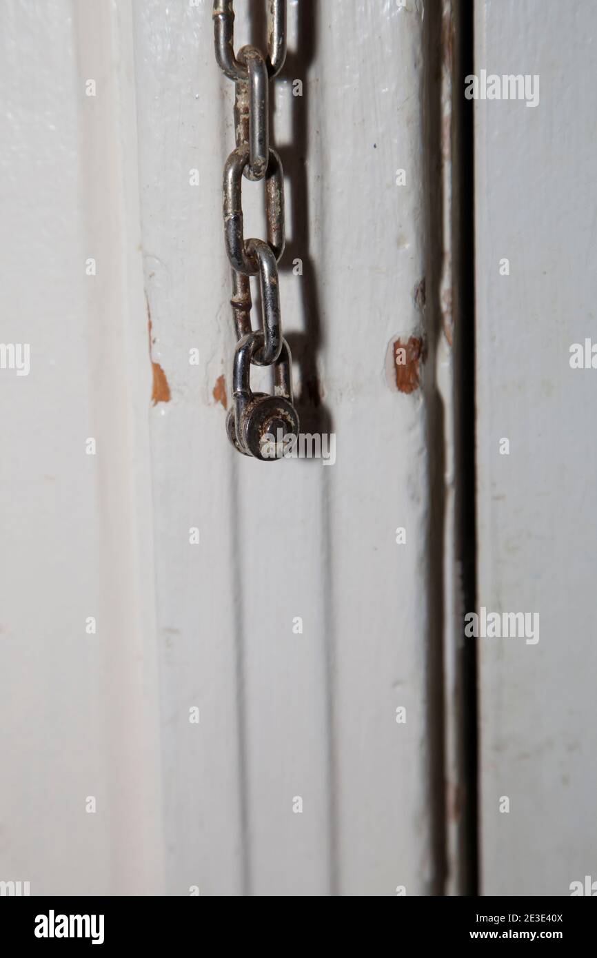 Old door chain hanging on a door frame Stock Photo - Alamy