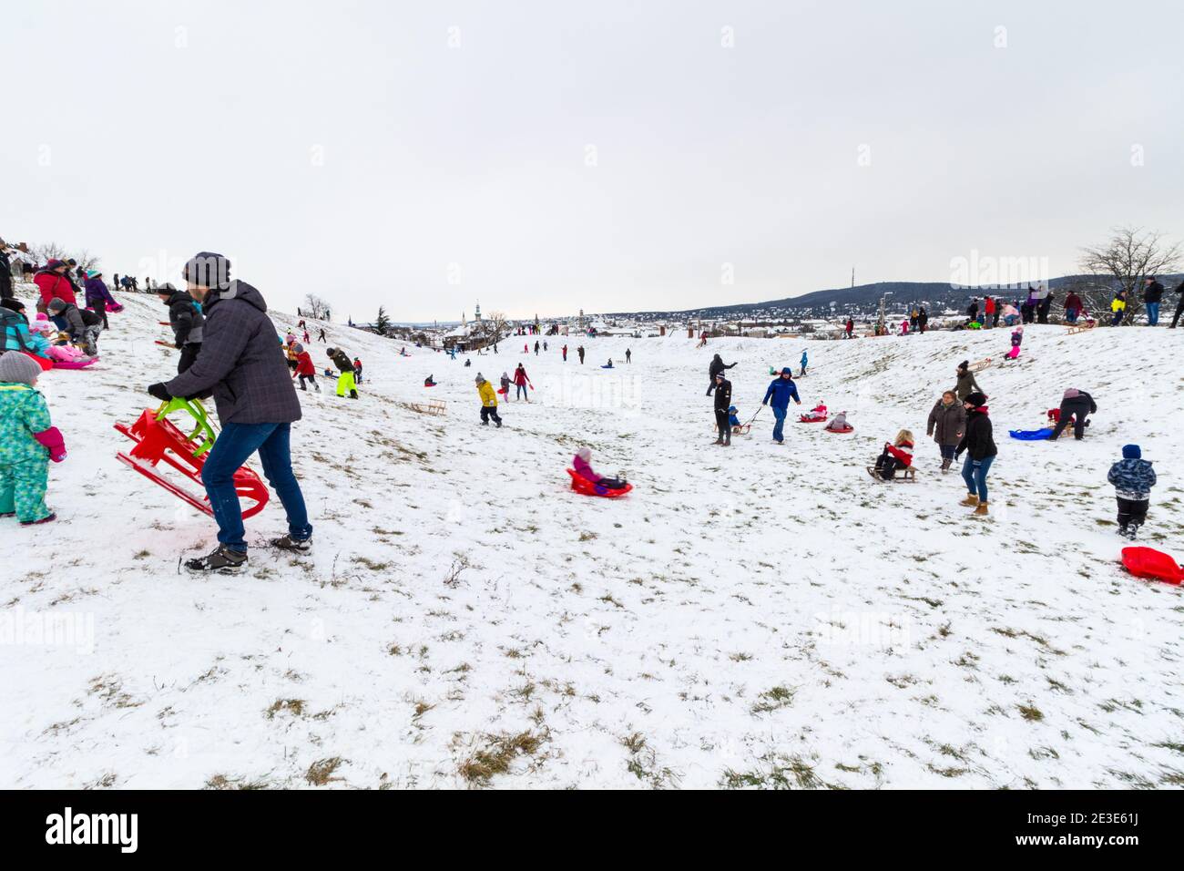 Peolpe children and adults sledging on the site of the ancient ...