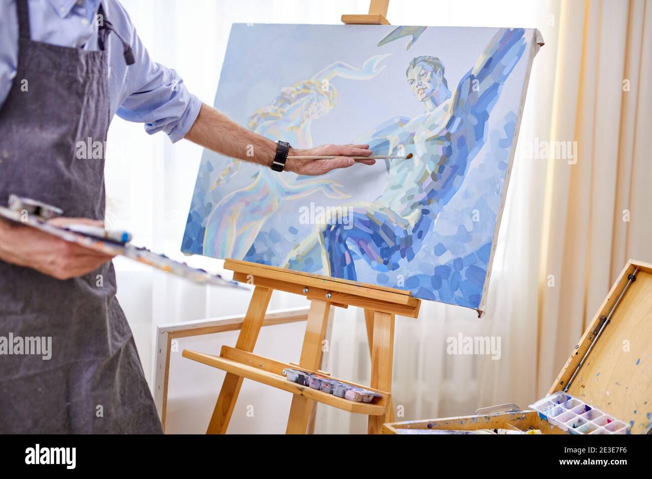 artist applying paint on canvas with paintbrush, his mind full of ...
