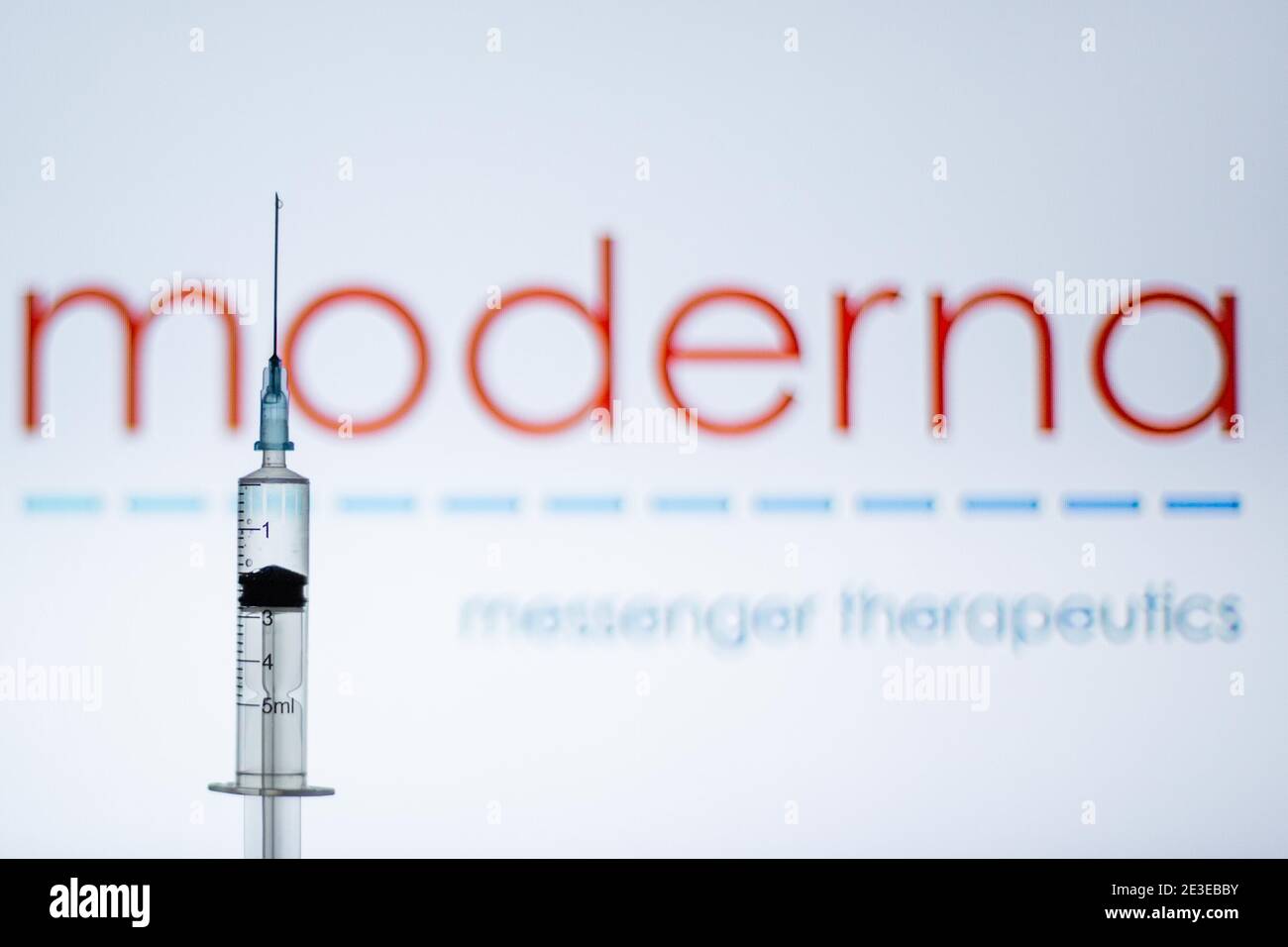 In this illustration, a syringe is seen in front of the Moderna logo ...