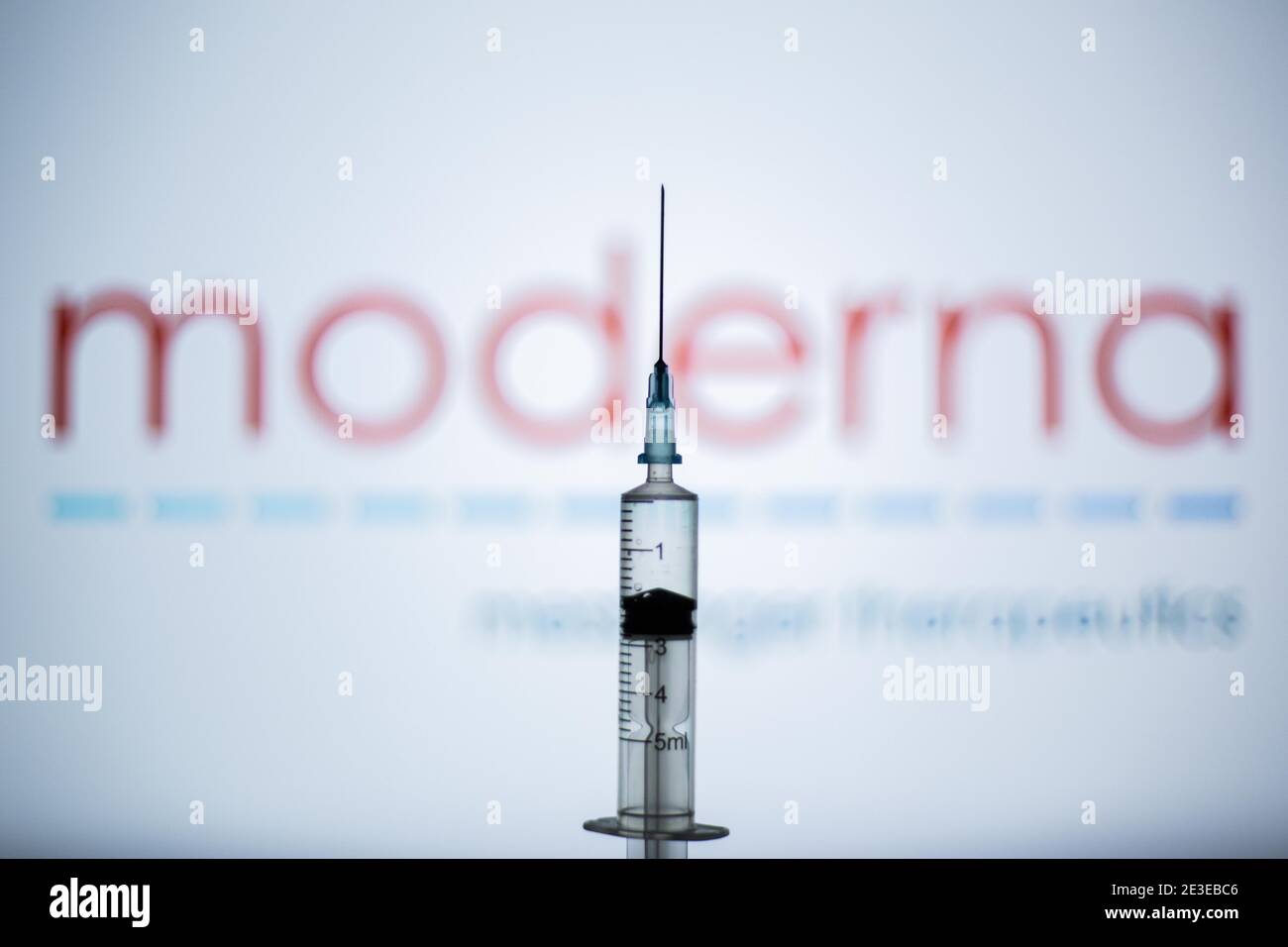 In this illustration, a syringe is seen in front of the Moderna logo ...