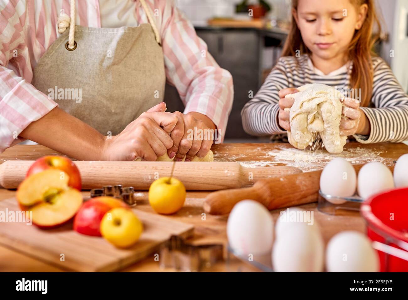 daughter helping mum kneading preparing dough in modern kitchen, happy ...