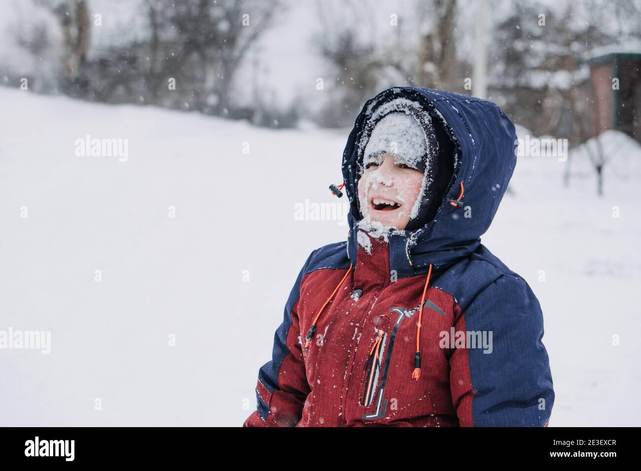 Close up outdoor winter portrait of boy face in the snow. Authentic ...