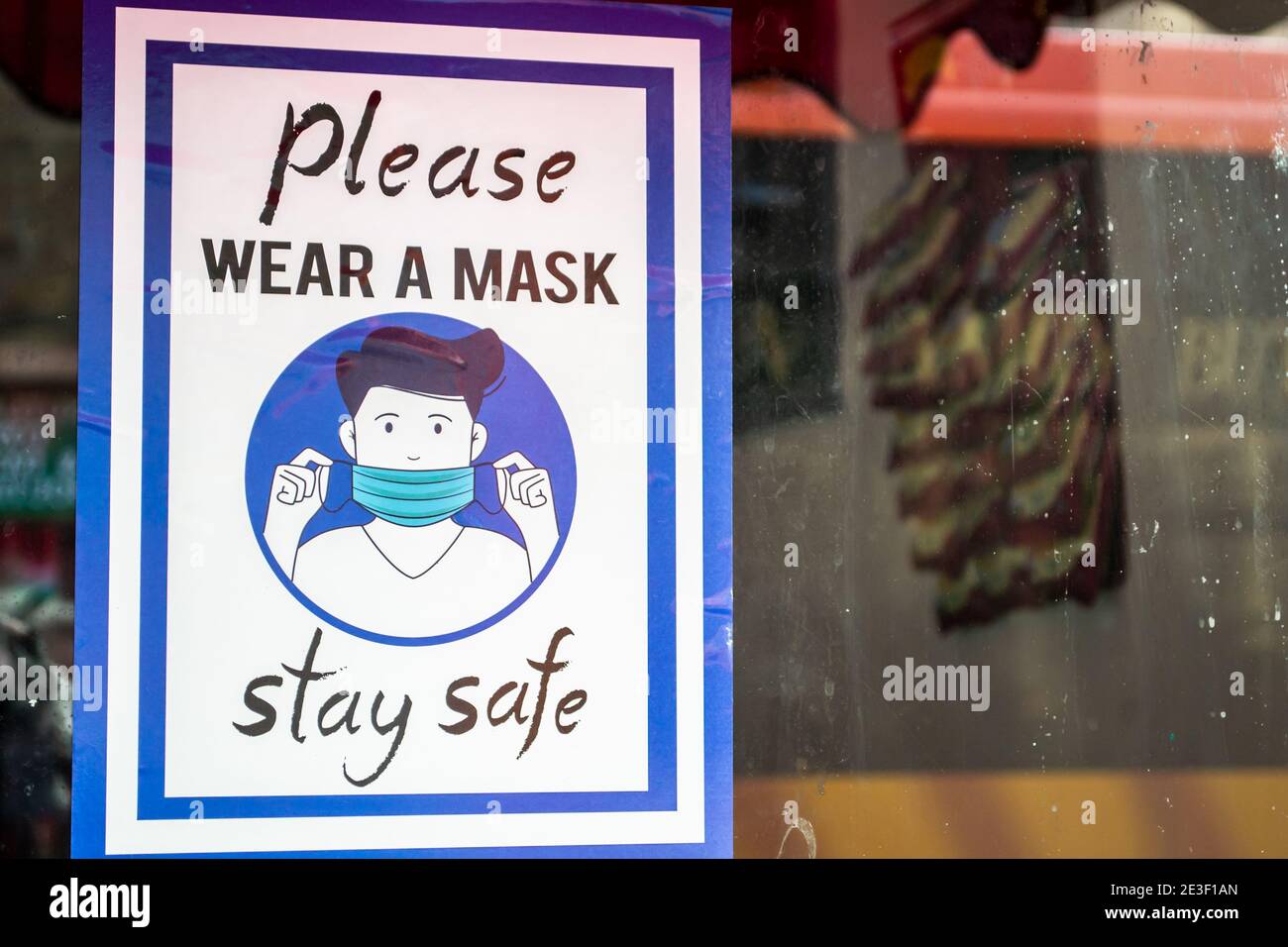 PLEASE WEAR A MASK poster in a shop window Stock Photo - Alamy
