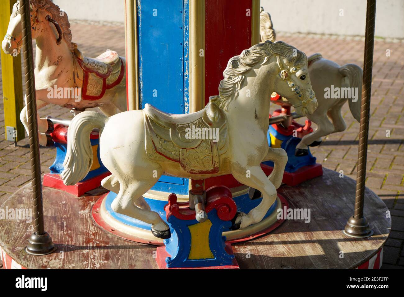 Small merry go round with three horses for kids Stock Photo - Alamy