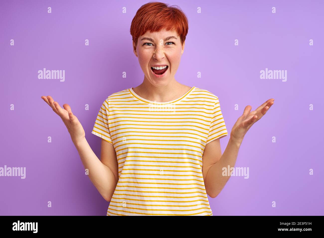 angry redhead woman screaming at camera isolated on purple background ...