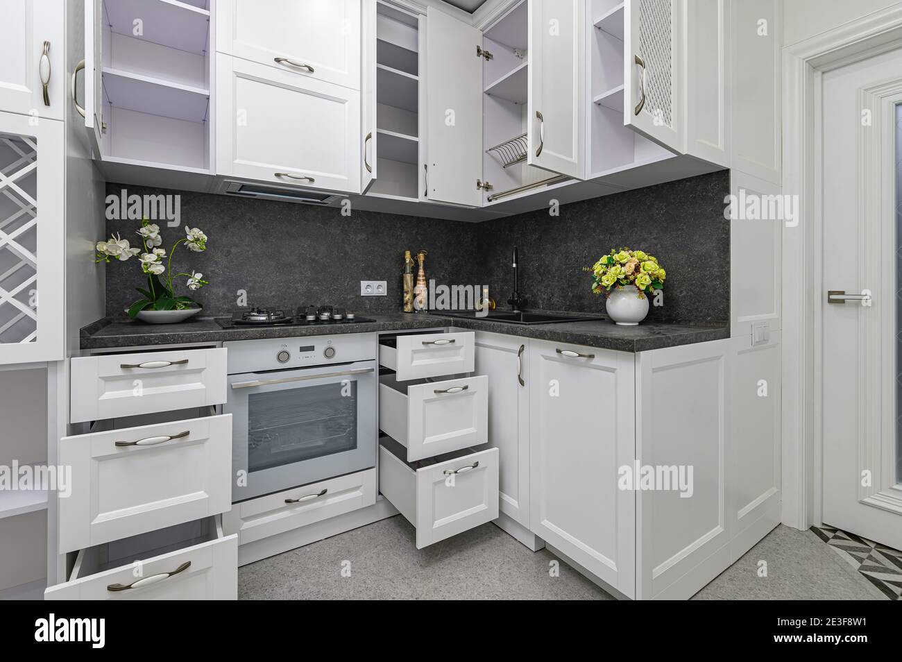 Open doors and drawers open at modern white kitchen Stock Photo - Alamy