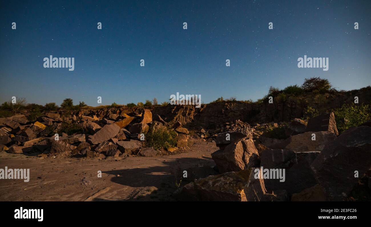 Beautiful lake surrounded by large piles of stone waste from hard work ...
