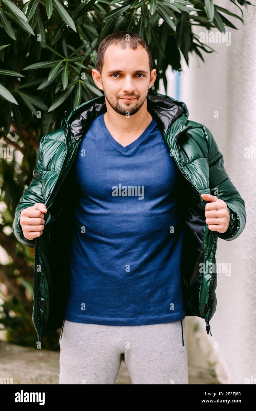 man wearing blue t-shirt mockup and jacket outdoors Stock Photo - Alamy