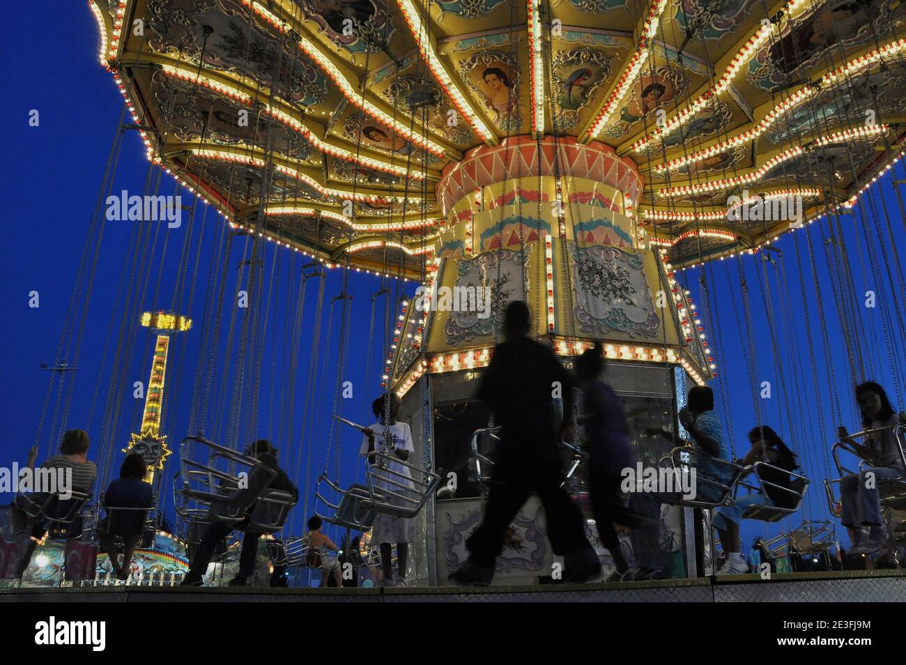 Swing ride at fair spinning around at twilight Stock Photo - Alamy