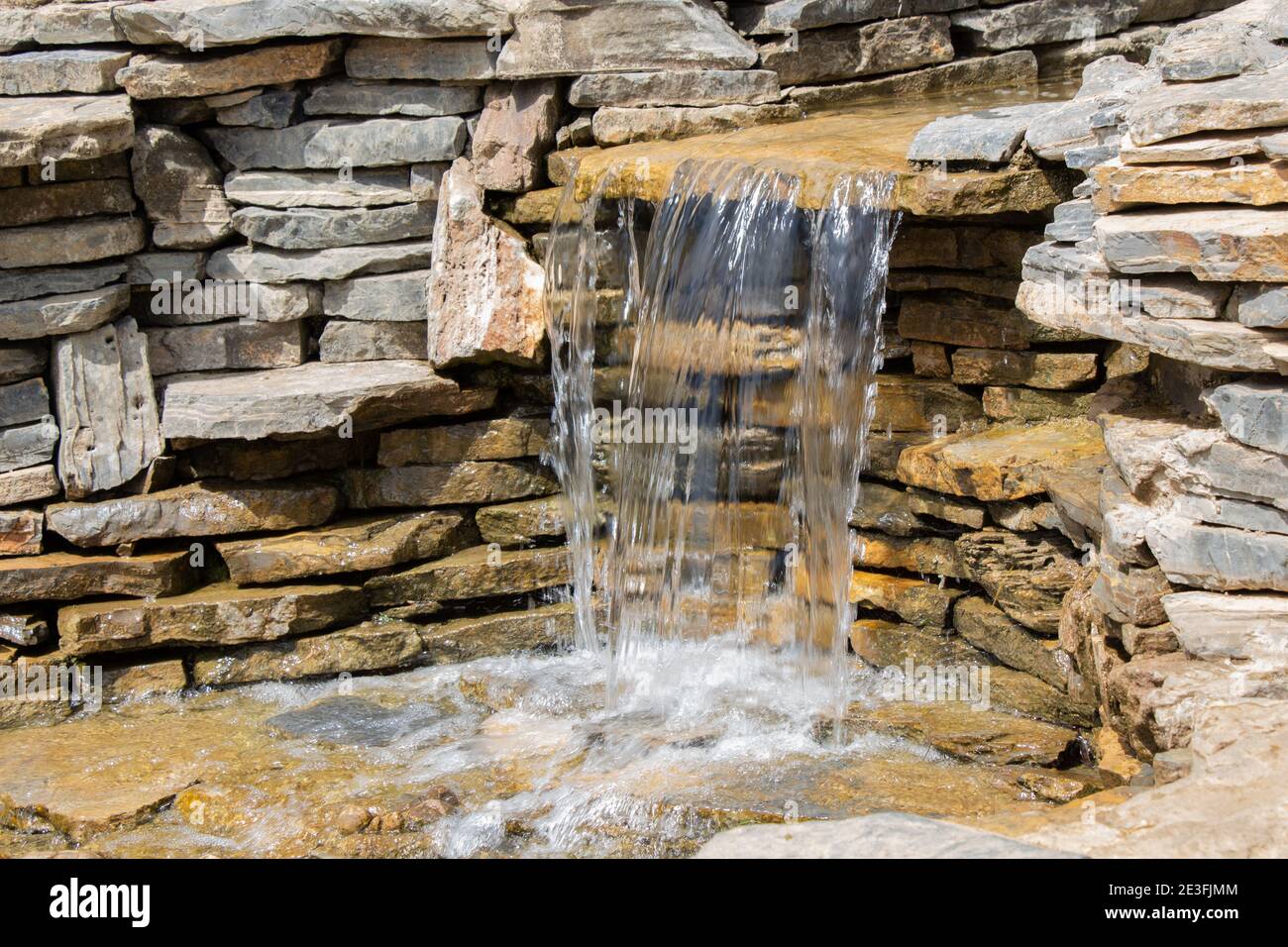 Small rocky waterfall pouring into a small pool Stock Photo - Alamy