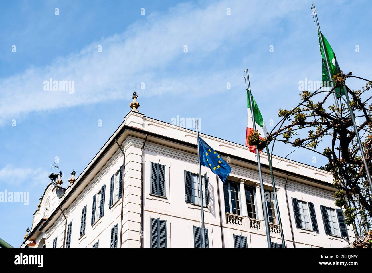 Flag of the European Union and Italy on high flagpoles in front of a ...