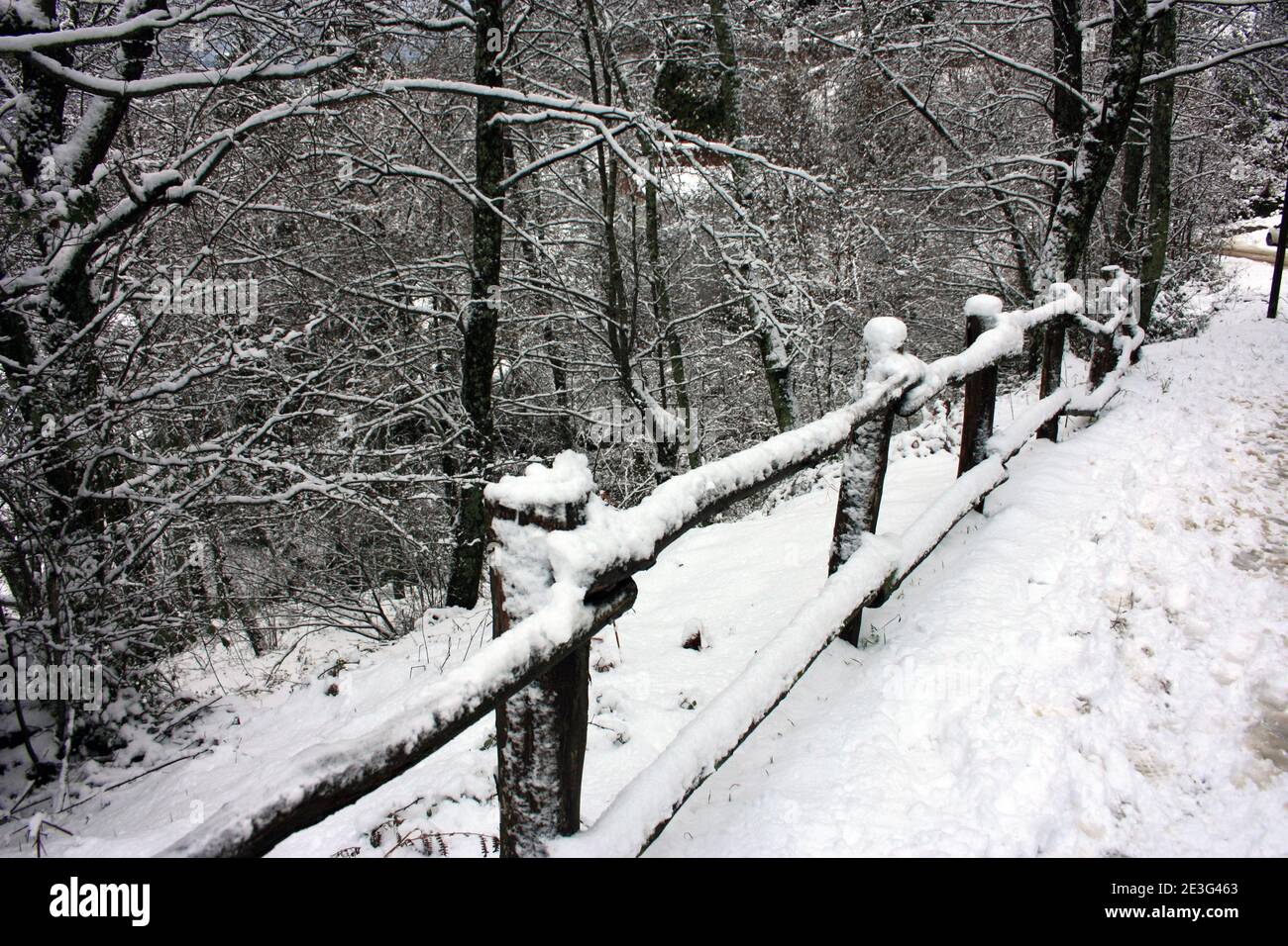 wooden fence covered in white snow along the road that runs alongside ...