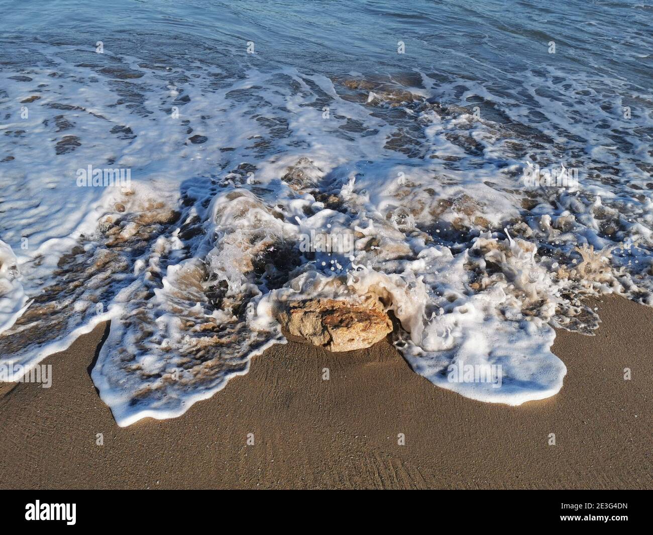 High angle shot of a wavy ocean with a sandy beach Stock Photo - Alamy