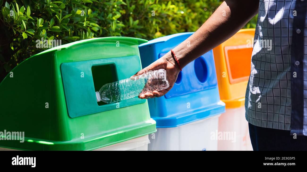 Selective focus close up the man black hand throwing an empty plastic water bottle in the ...