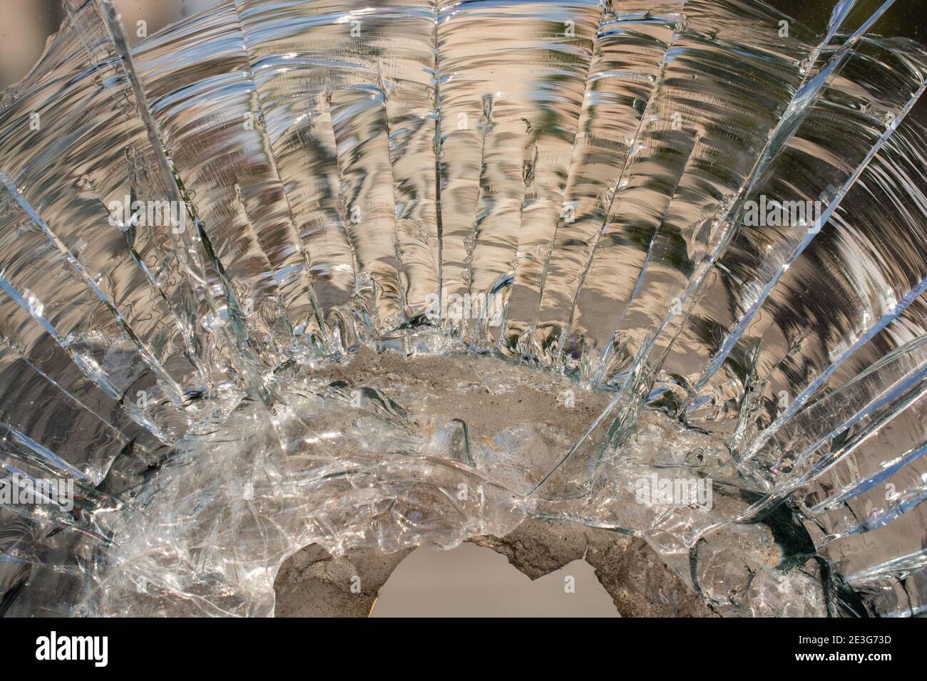 Damaged glass with a hole in shatters into small pieces Stock Photo - Alamy