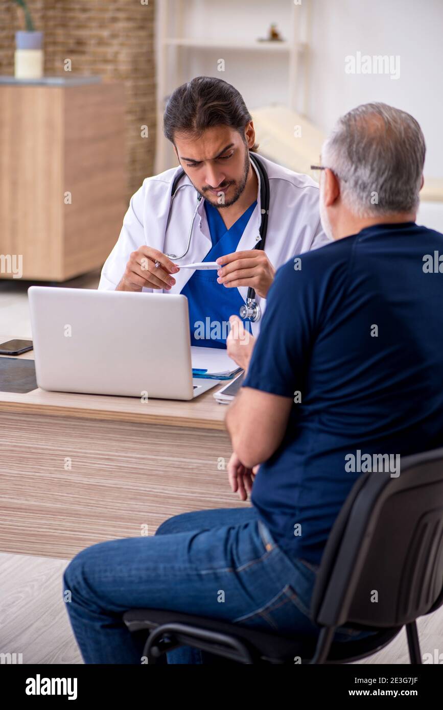 Old male patient visiting young doctor Stock Photo - Alamy