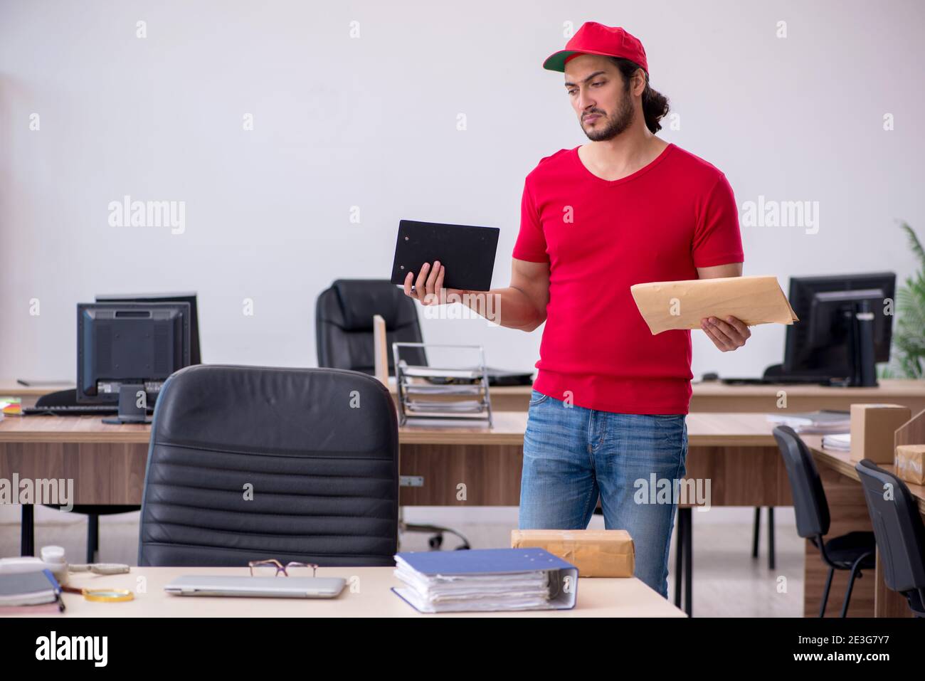 Young courier delivering post to the office Stock Photo - Alamy