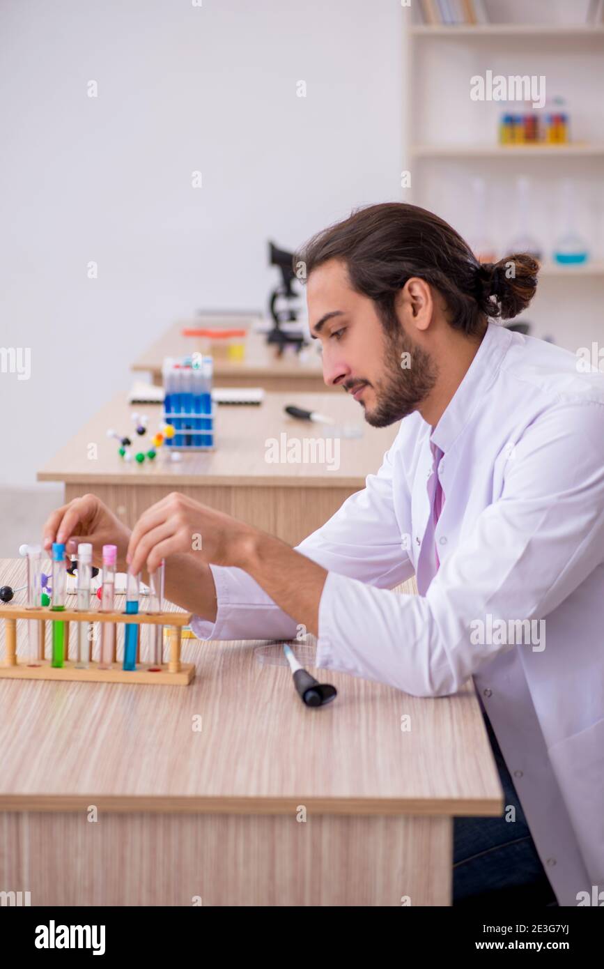 Young chemist sitting at the desk in the classroom Stock Photo - Alamy