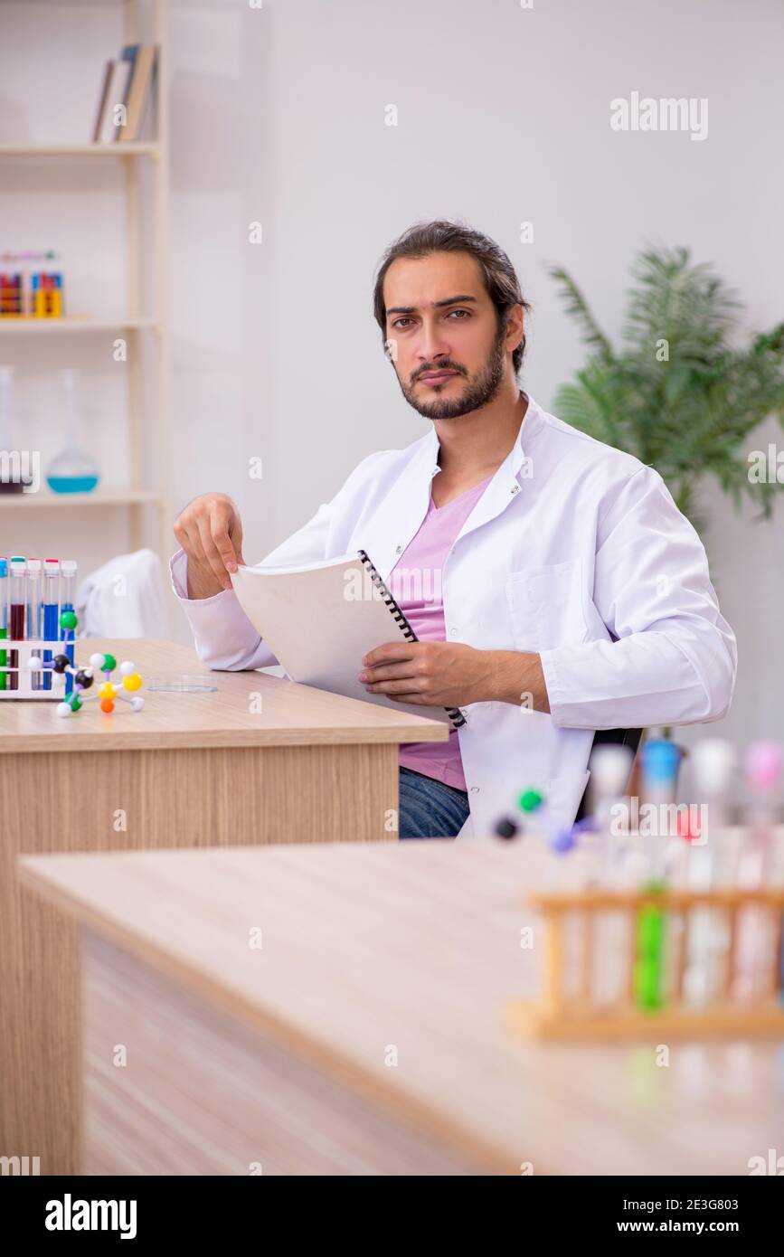 Young chemist sitting at the desk in the classroom Stock Photo - Alamy
