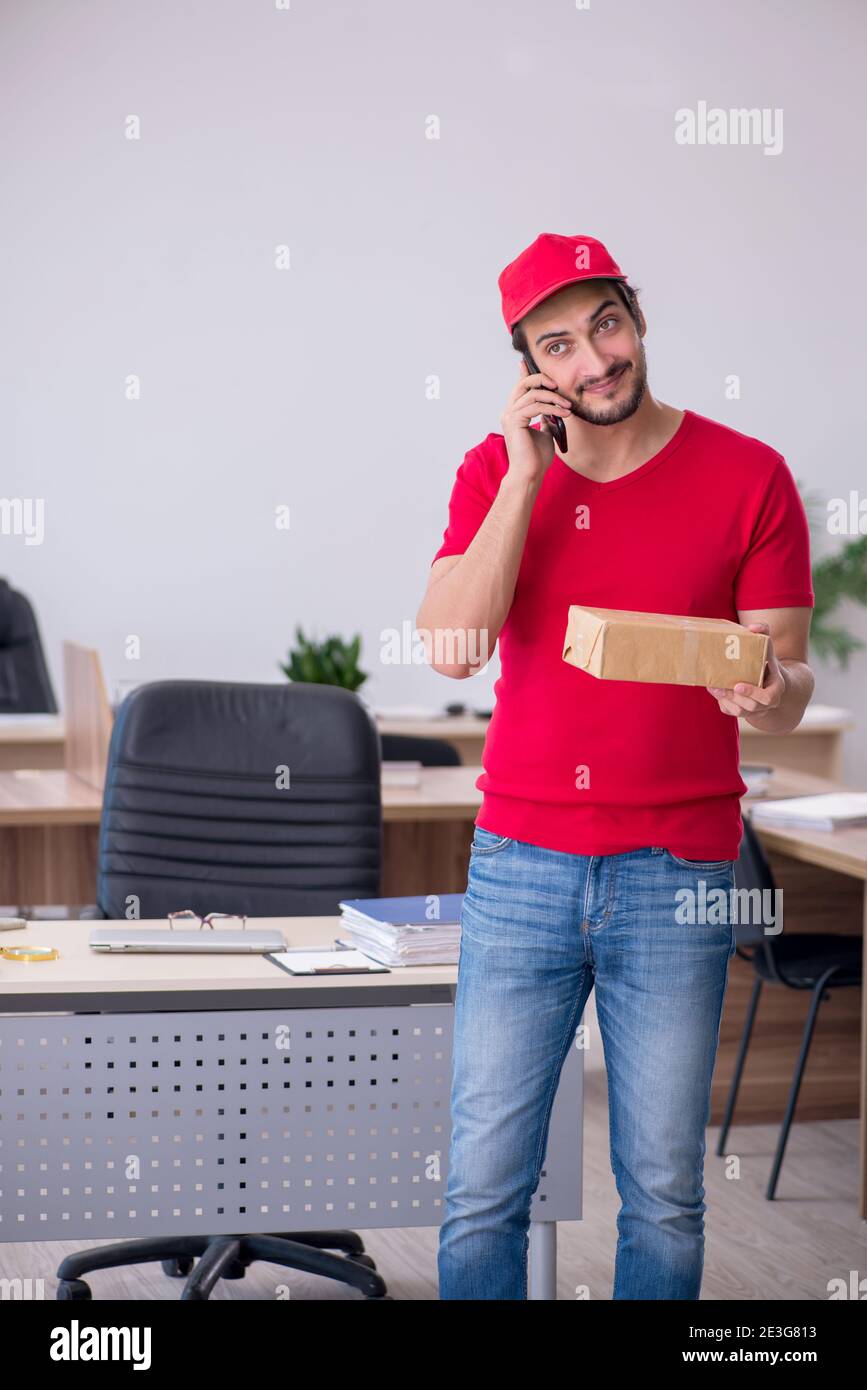 Young courier delivering post to the office Stock Photo - Alamy