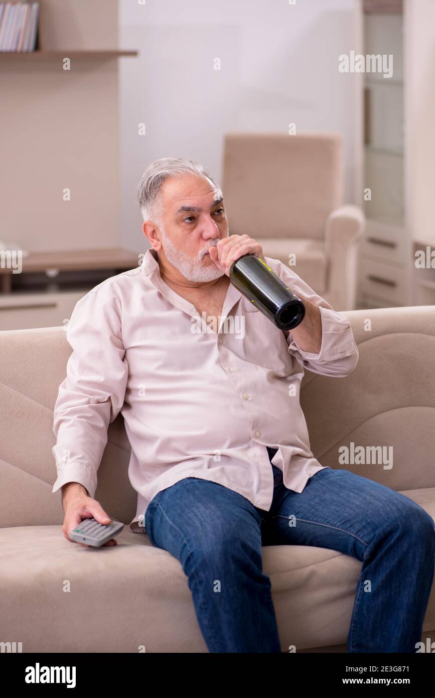 Aged man drinking alcohol at home Stock Photo - Alamy