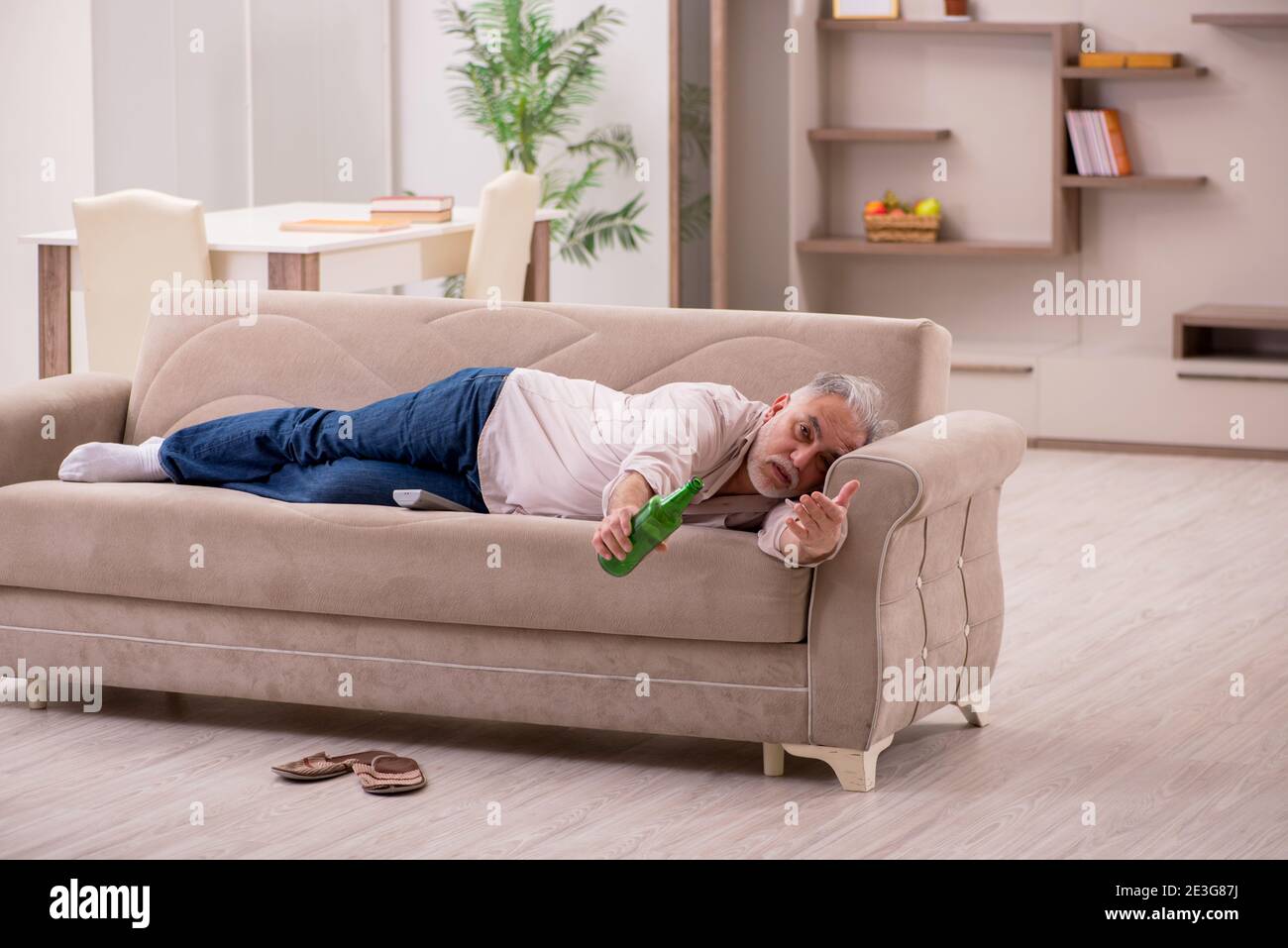 Aged man drinking alcohol at home Stock Photo - Alamy