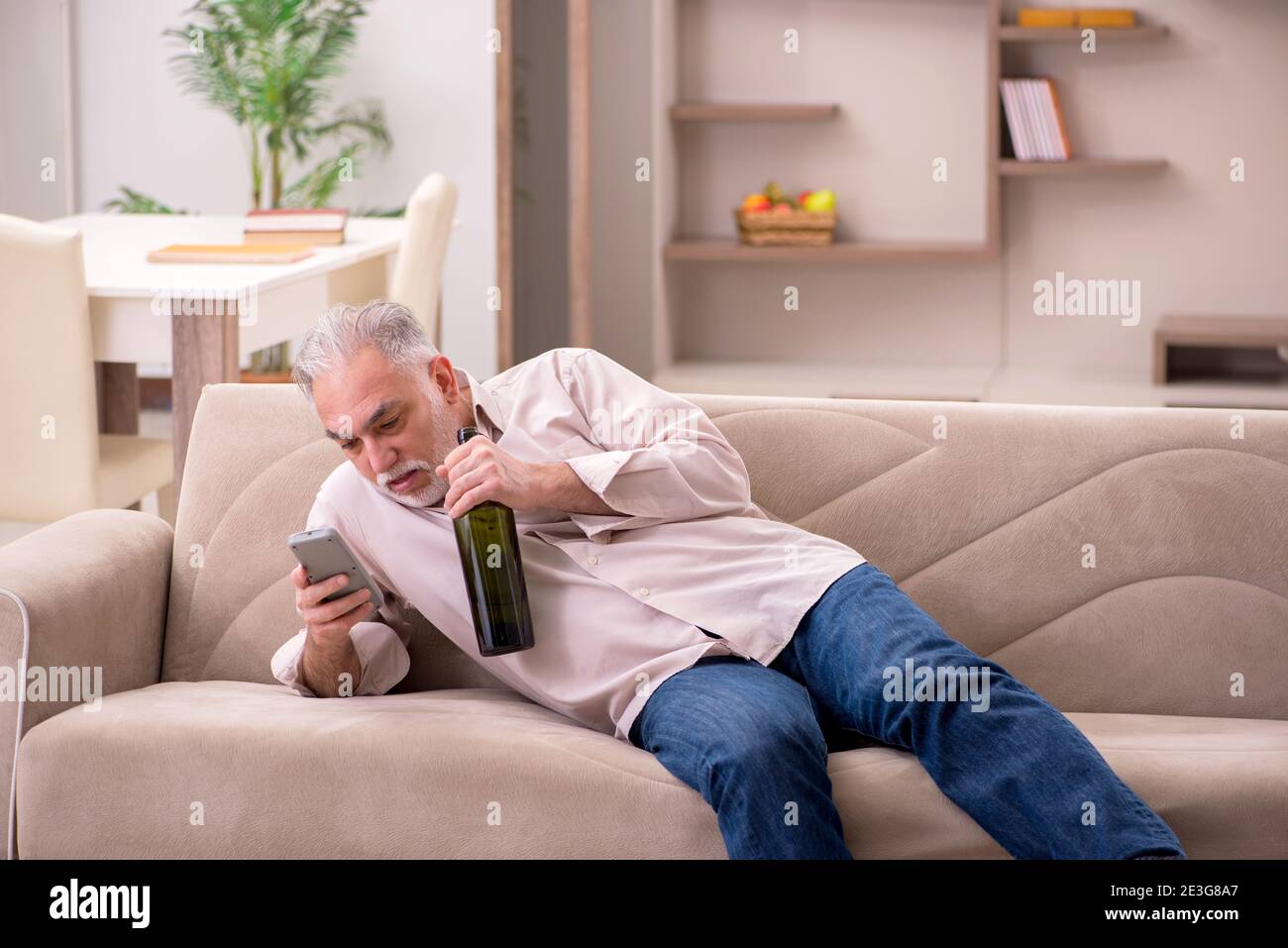 Aged man drinking alcohol at home Stock Photo - Alamy
