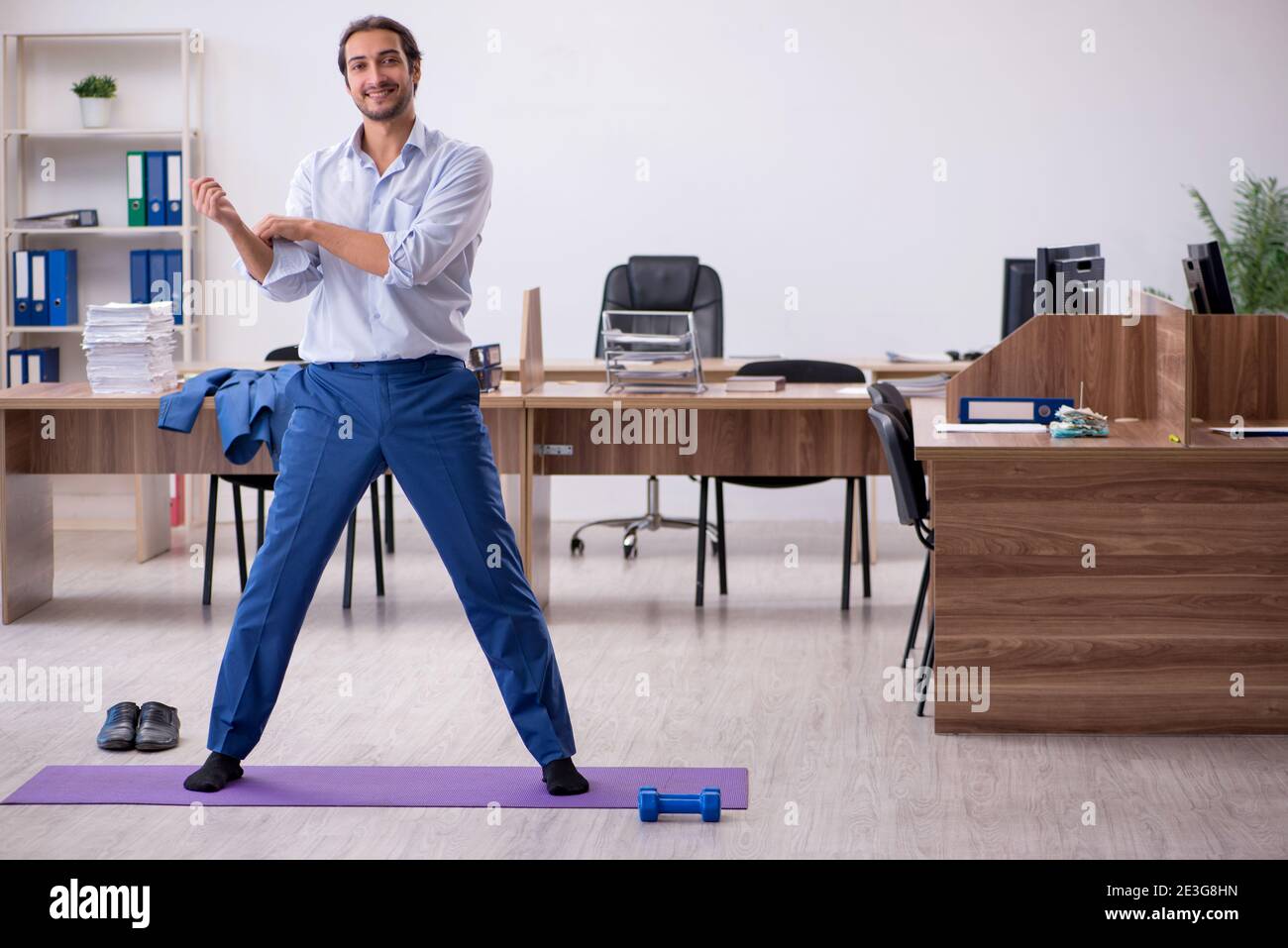 Young employee doing sport exercises during break Stock Photo - Alamy