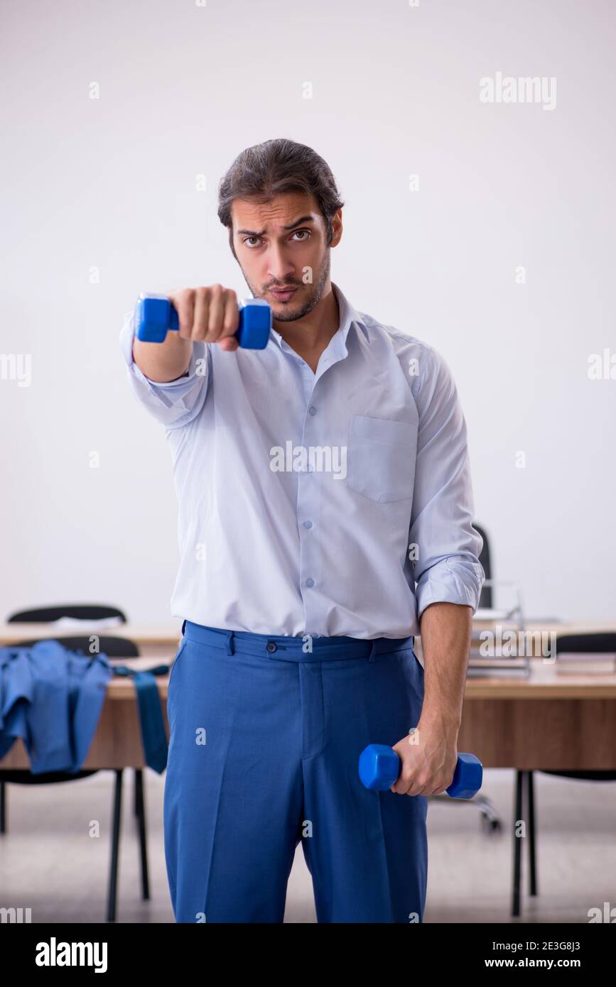 Young employee doing sport exercises during break Stock Photo - Alamy