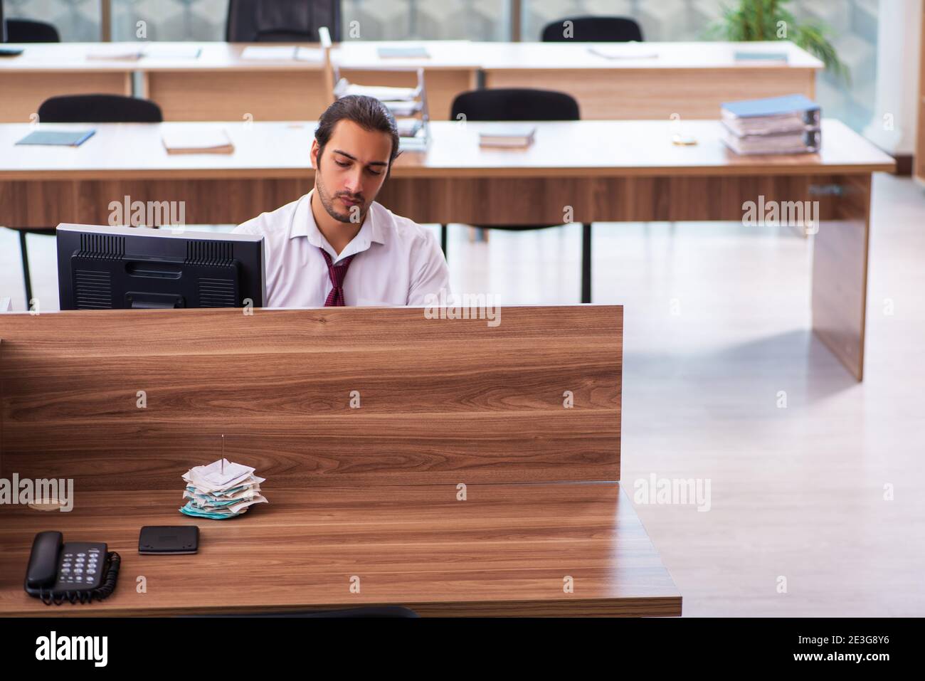 Young employee and too many work in the office Stock Photo - Alamy