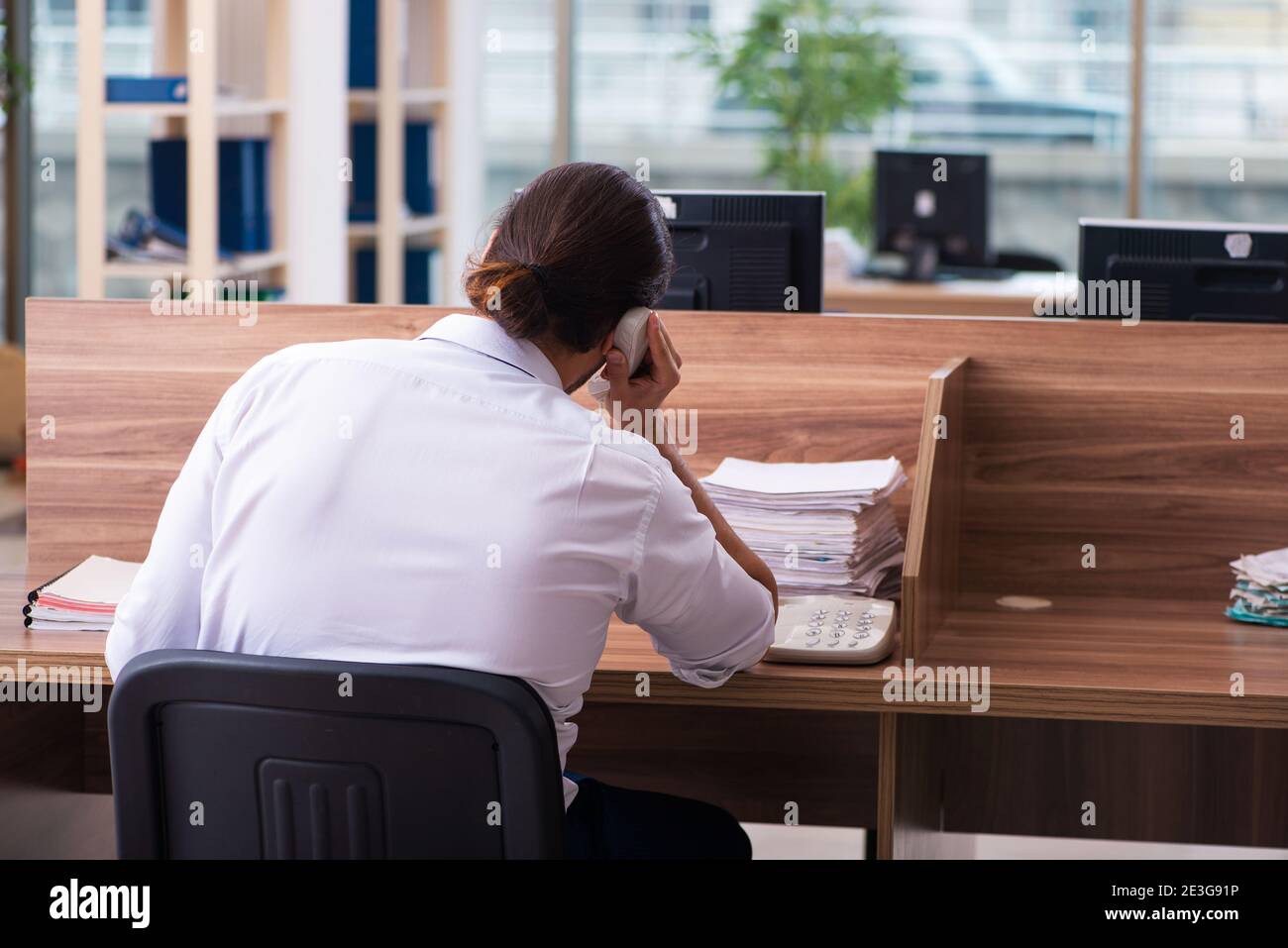 Young employee and too many work in the office Stock Photo - Alamy