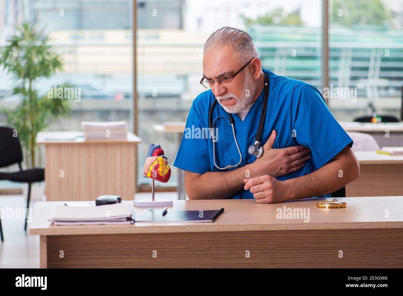 Old doctor cardiologist working in the clinic Stock Photo - Alamy