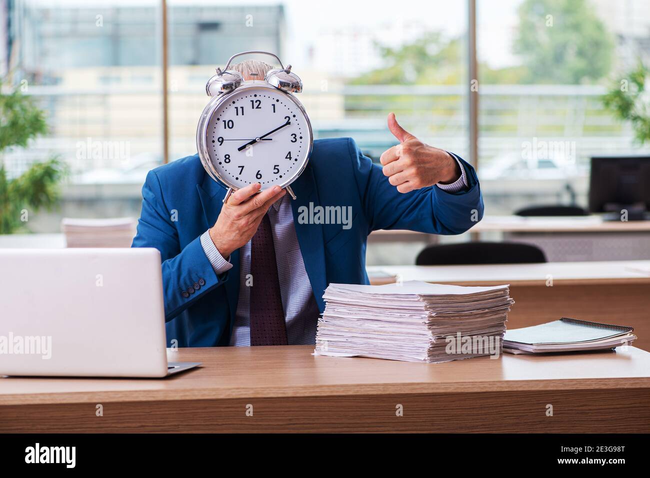 Old boss employee in time management concept Stock Photo - Alamy