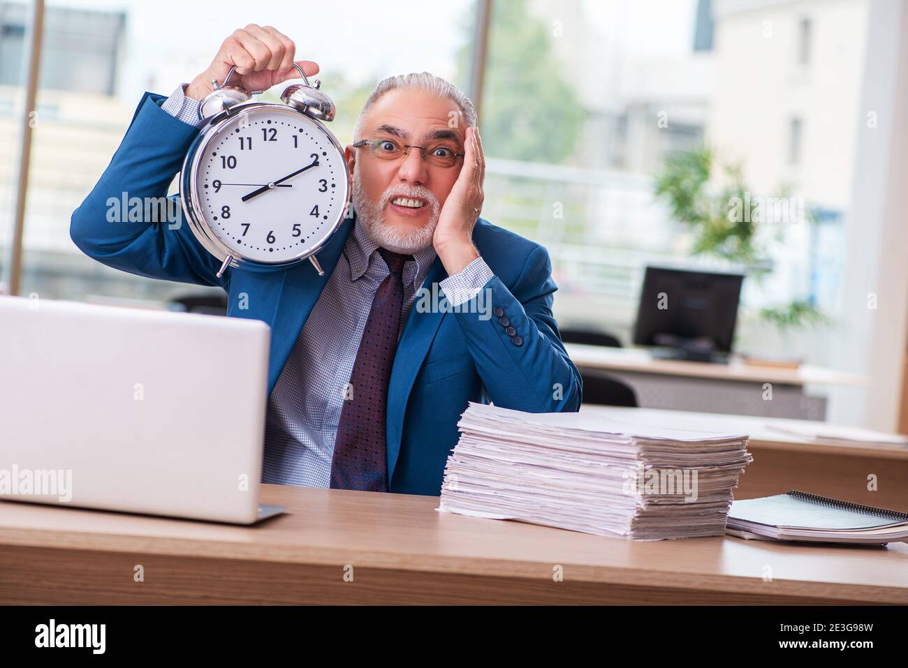 Old boss employee in time management concept Stock Photo - Alamy