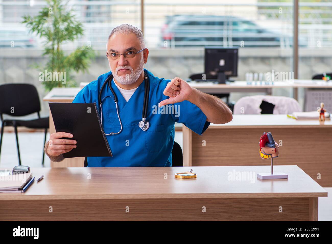 Old doctor working in the clinic Stock Photo - Alamy