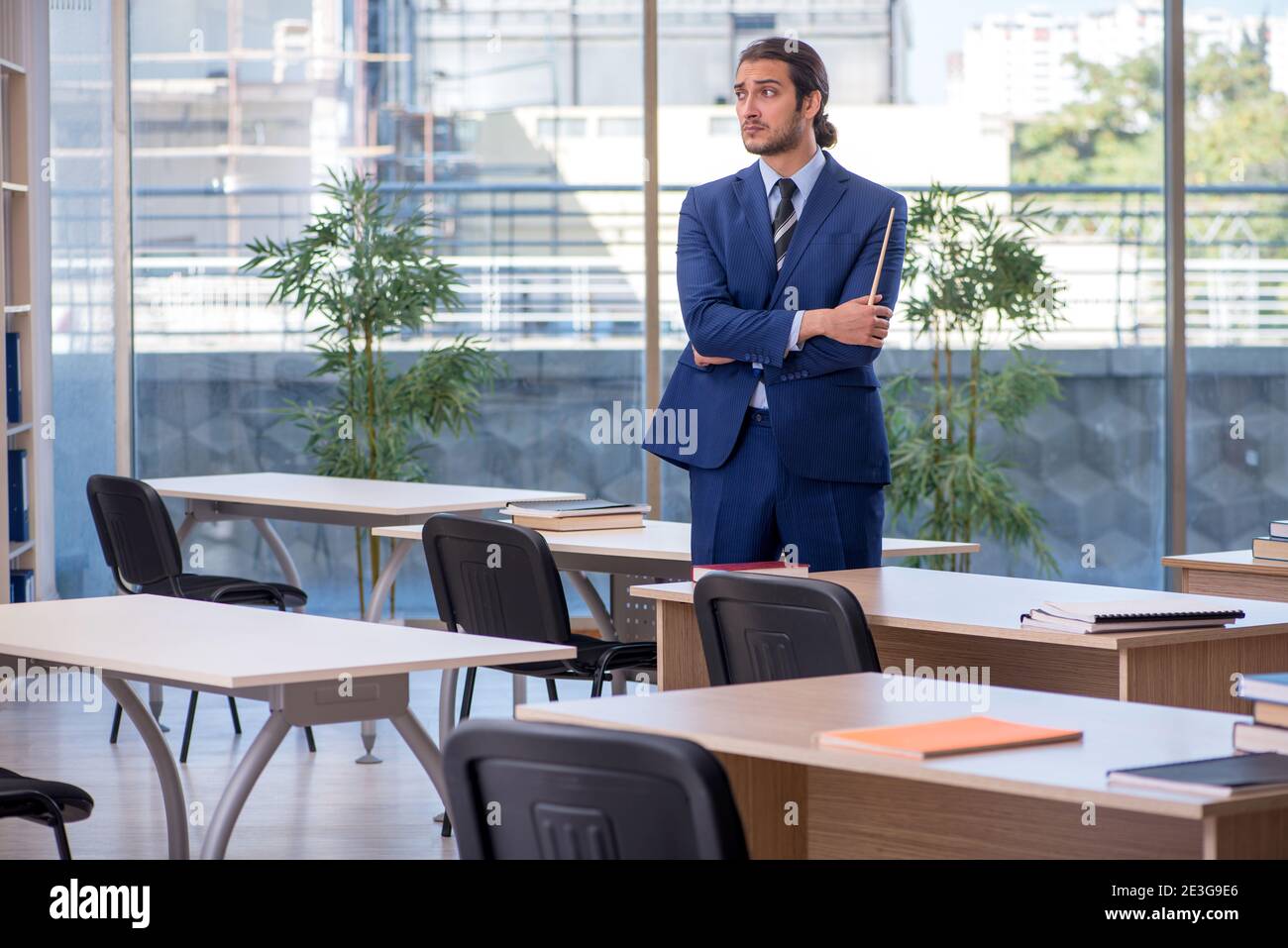 Young teacher in suit in the classroom Stock Photo - Alamy