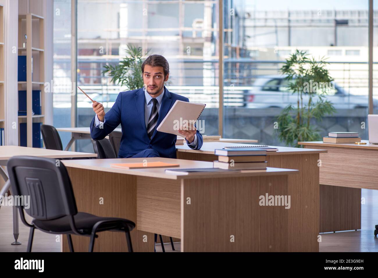Young teacher in suit in the classroom Stock Photo - Alamy
