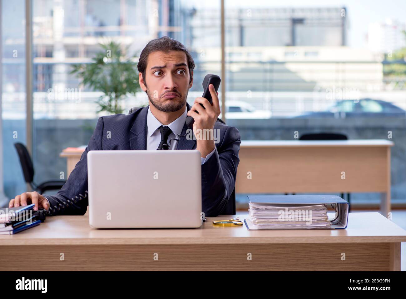 Young male employee working in the office Stock Photo - Alamy