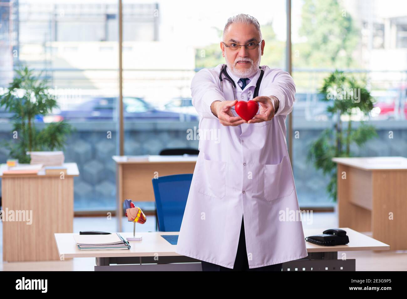 Old doctor cardiologist working in the clinic Stock Photo - Alamy