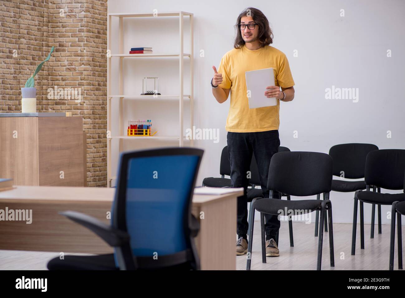 Young student waiting for teacher in the classroom Stock Photo - Alamy