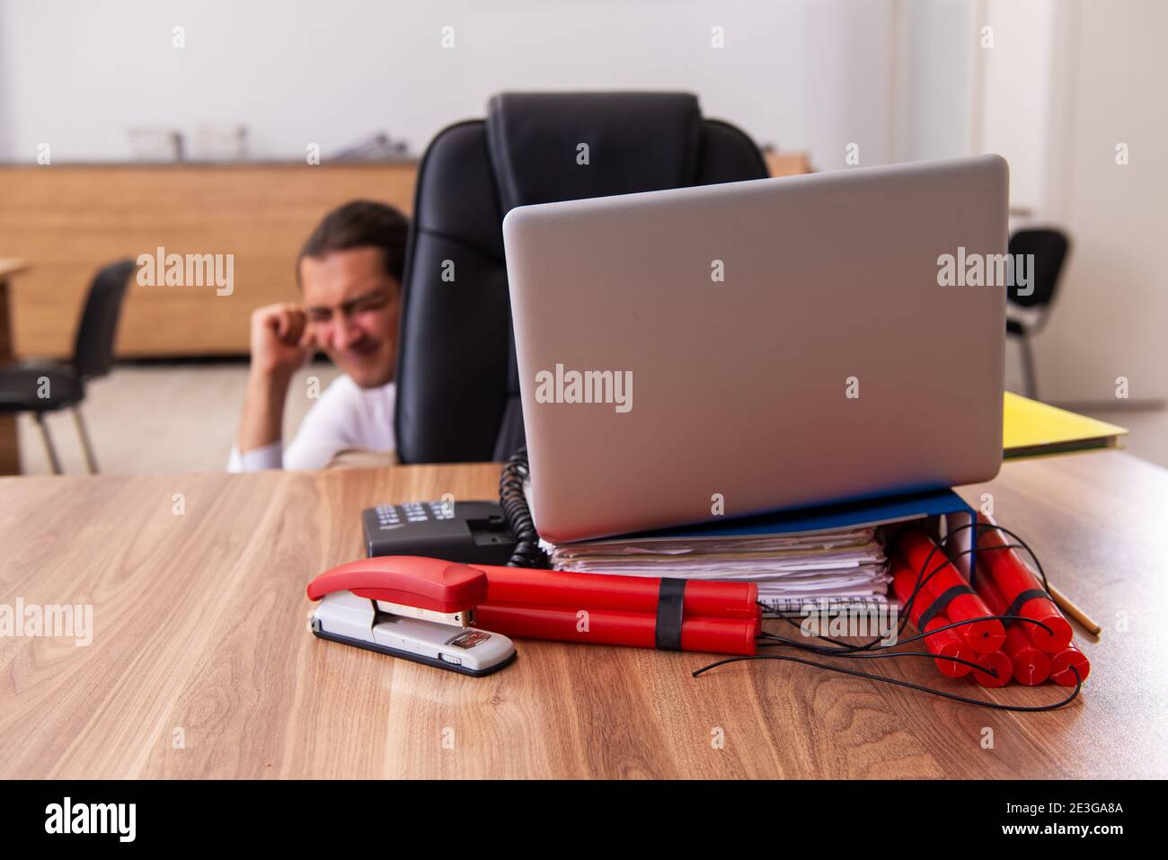 Young businessman employee with dynamite in the office Stock Photo - Alamy