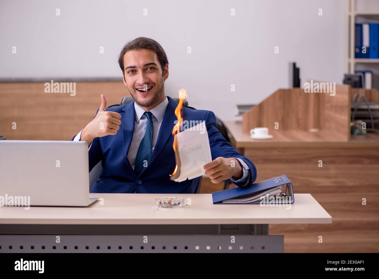 Young man employee burning papers in the office Stock Photo - Alamy