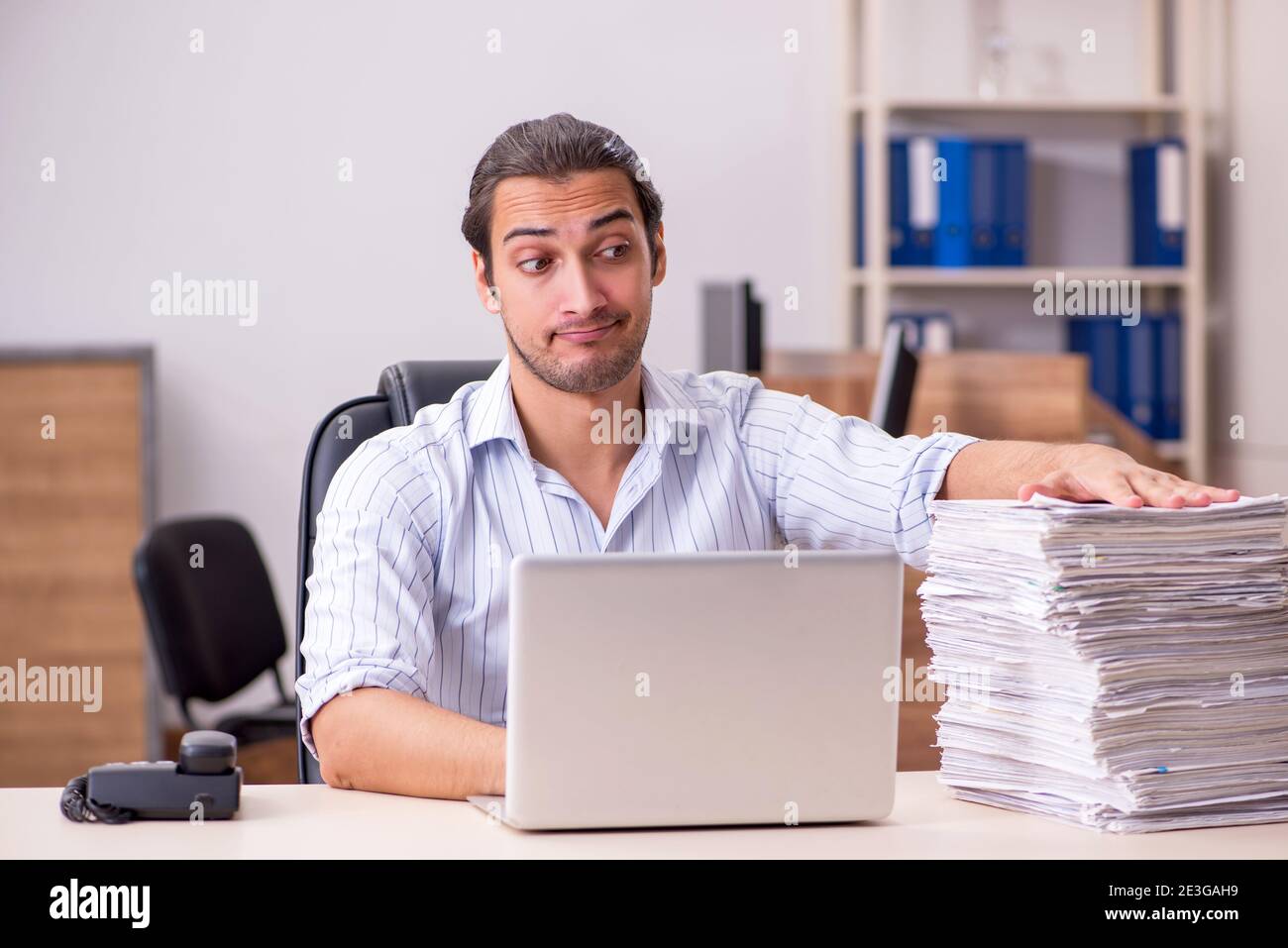 Young employee and many paperwork in the office Stock Photo - Alamy